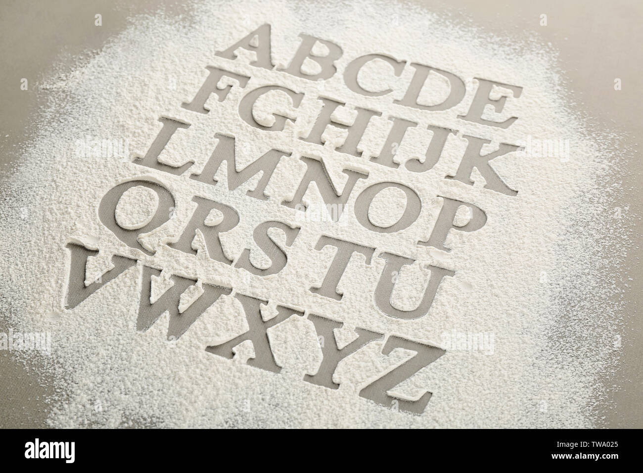 Silhouettes of alphabet letters on scattered flour Stock Photo - Alamy