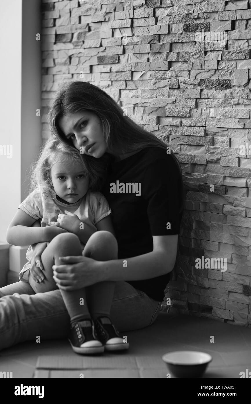 Homeless poor woman with little daughter sitting near brick wall Stock ...