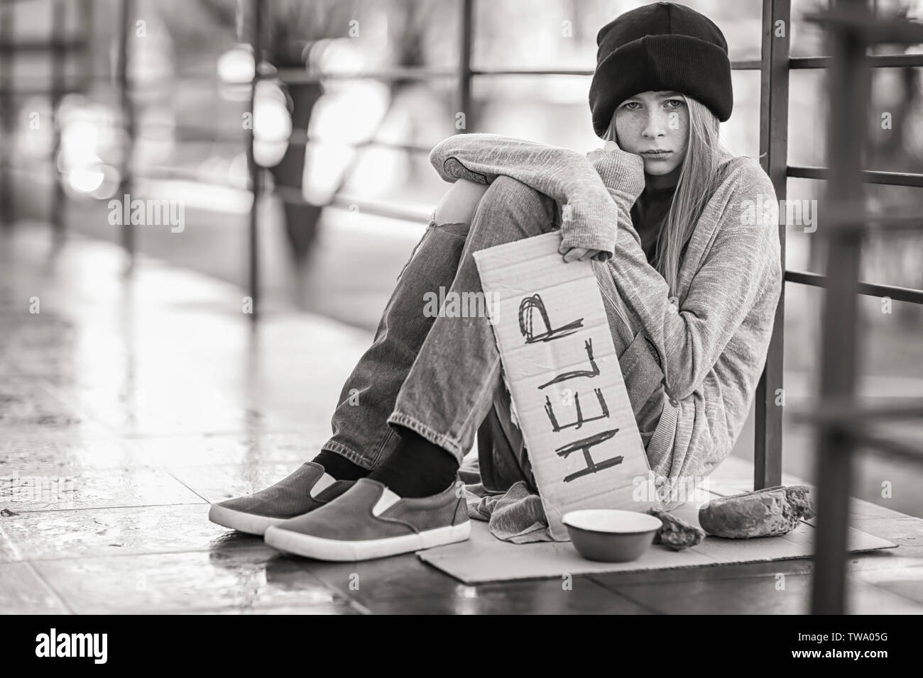 Homeless poor teenage girl holding piece of cardboard with word HELP ...