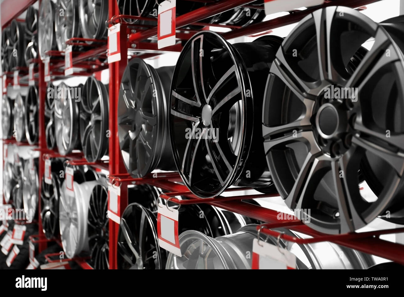 Stand with alloy wheels in modern tire store Stock Photo - Alamy