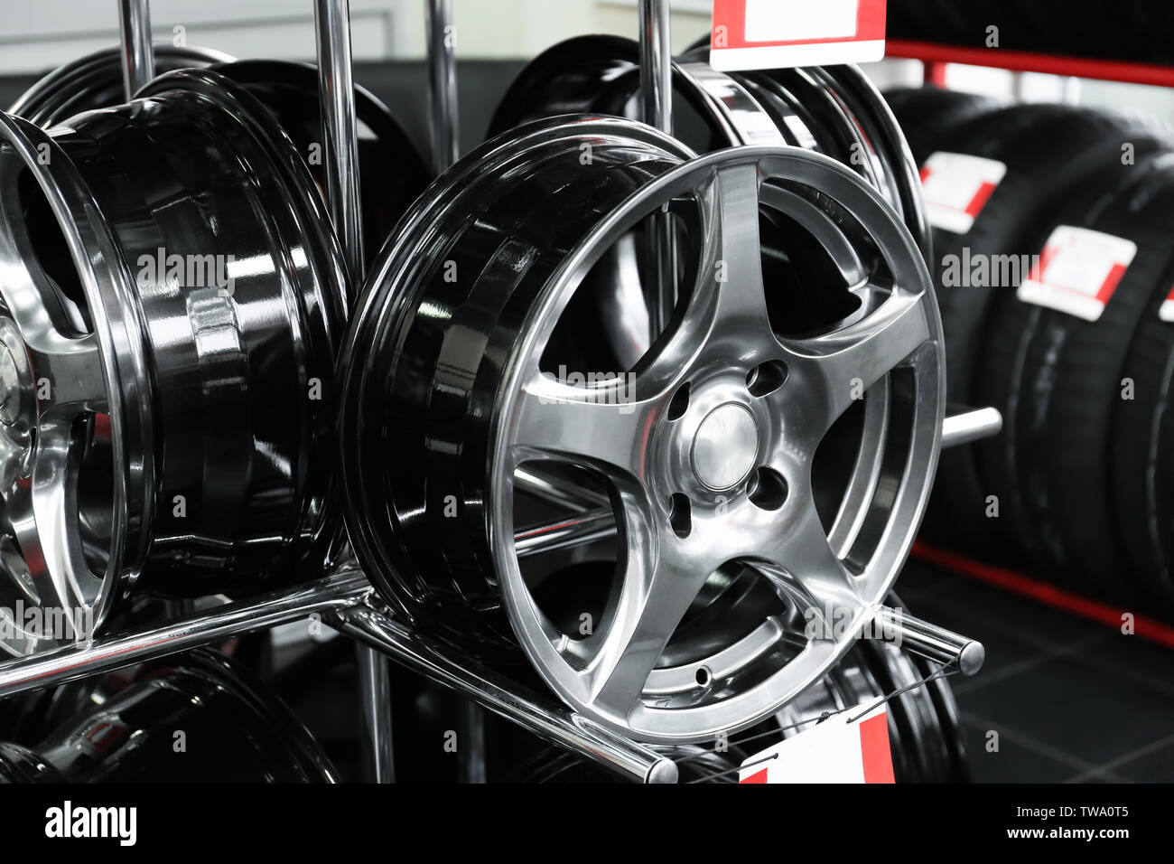 Stand with alloy wheels in modern tire store Stock Photo - Alamy