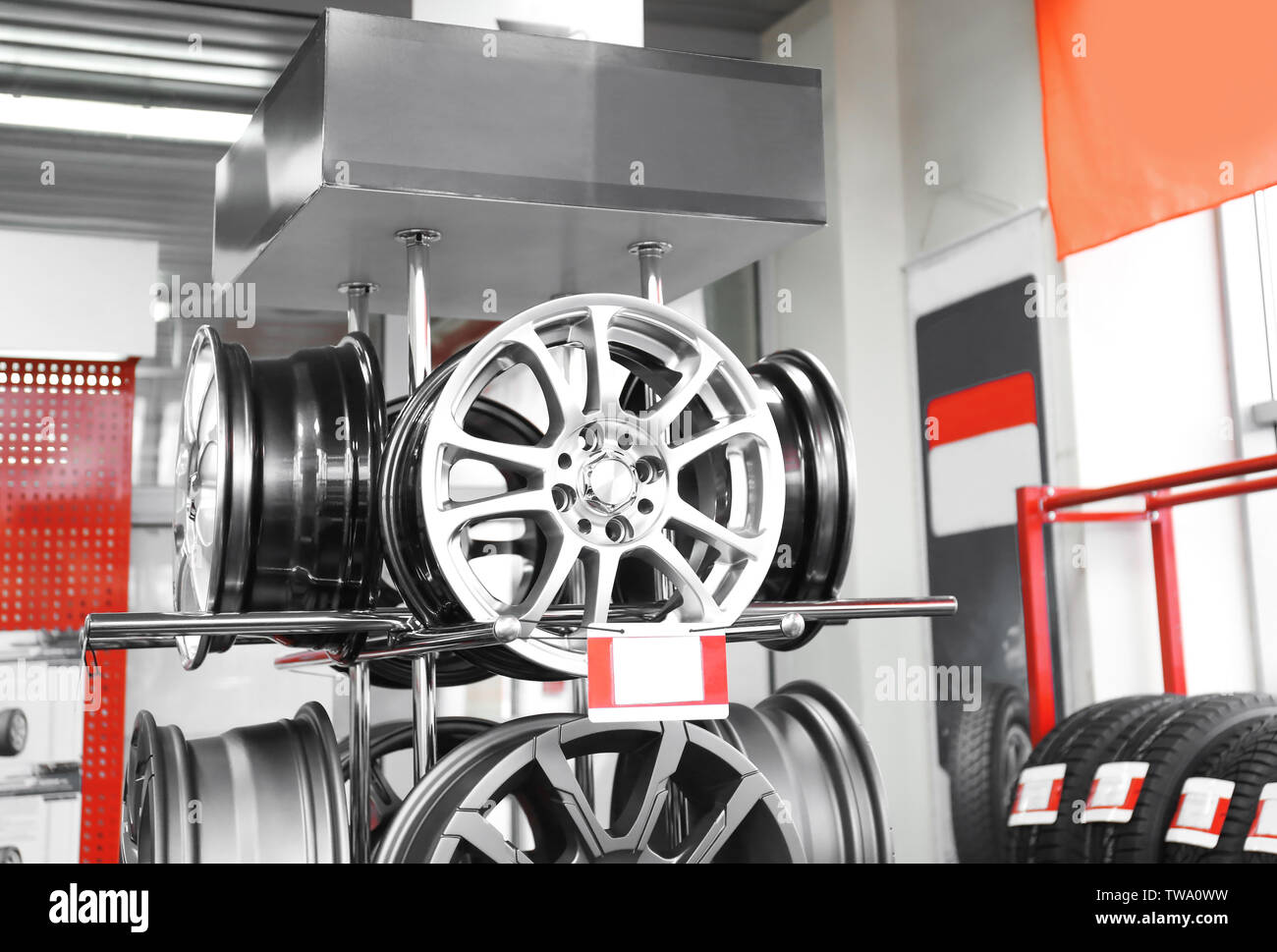 Stand with alloy wheels in modern tire store Stock Photo - Alamy