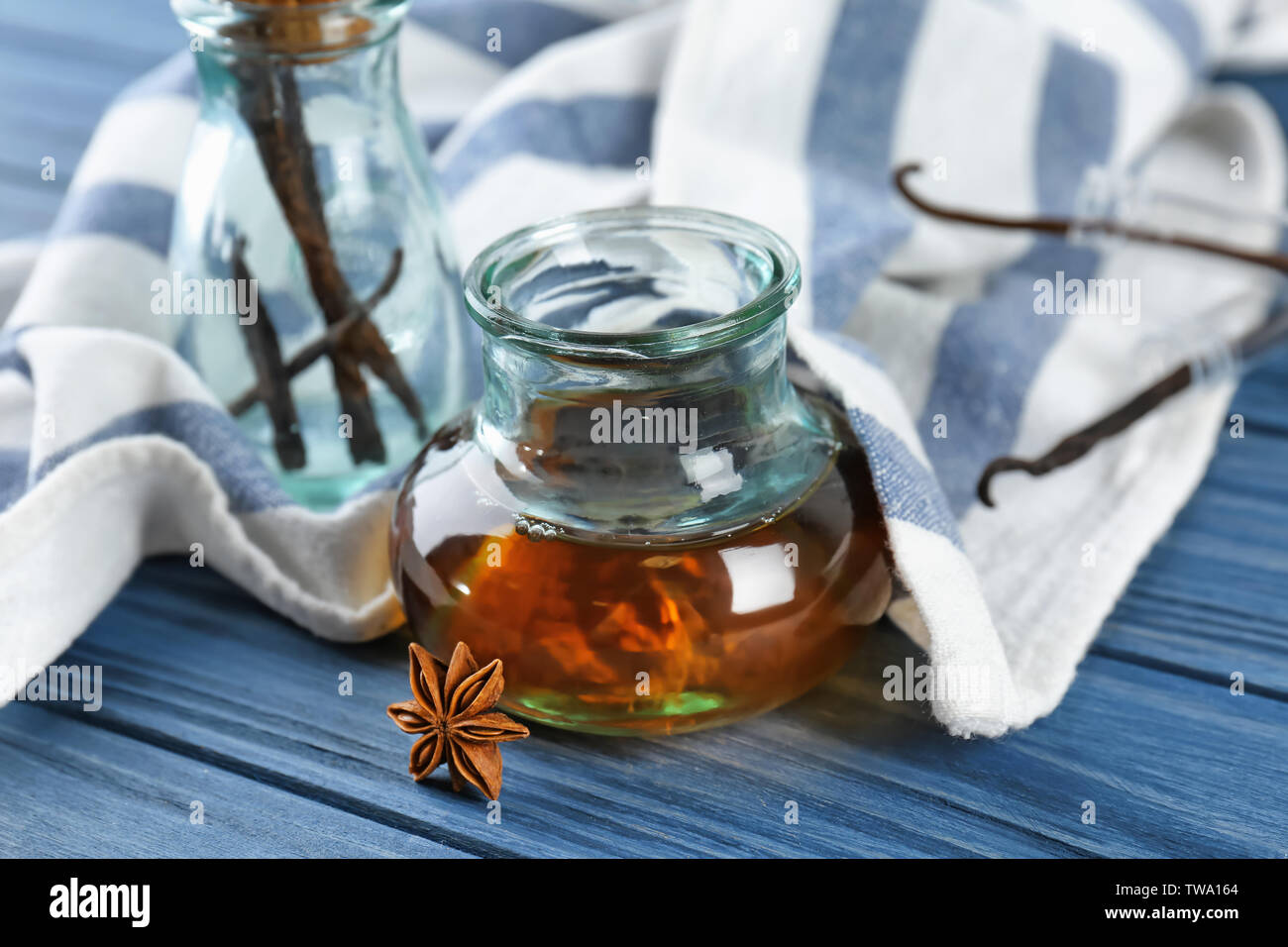Glass jar with vanilla extract on wooden table Stock Photo - Alamy