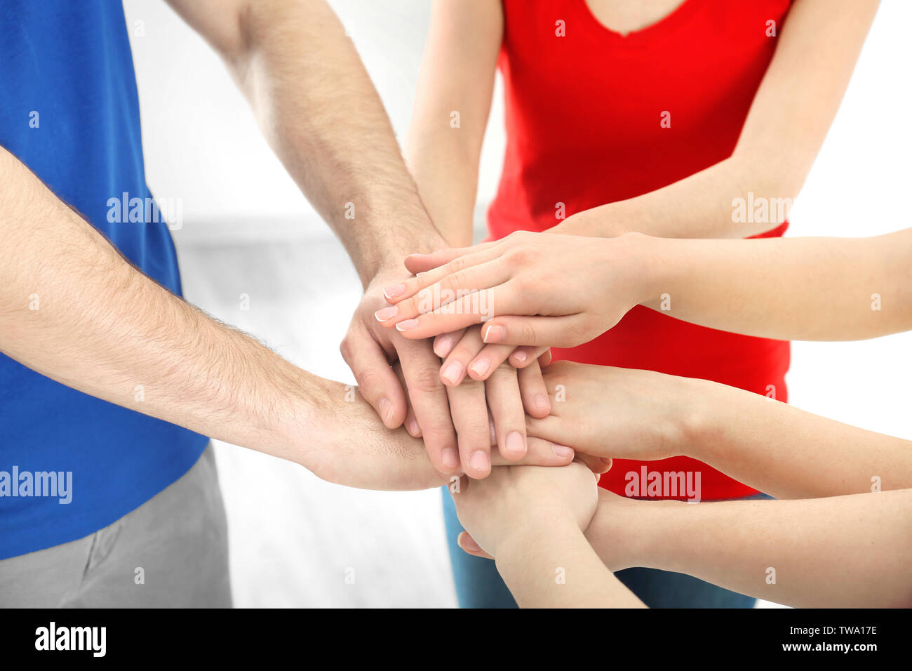 Young people putting hands together indoors. Unity concept Stock Photo ...