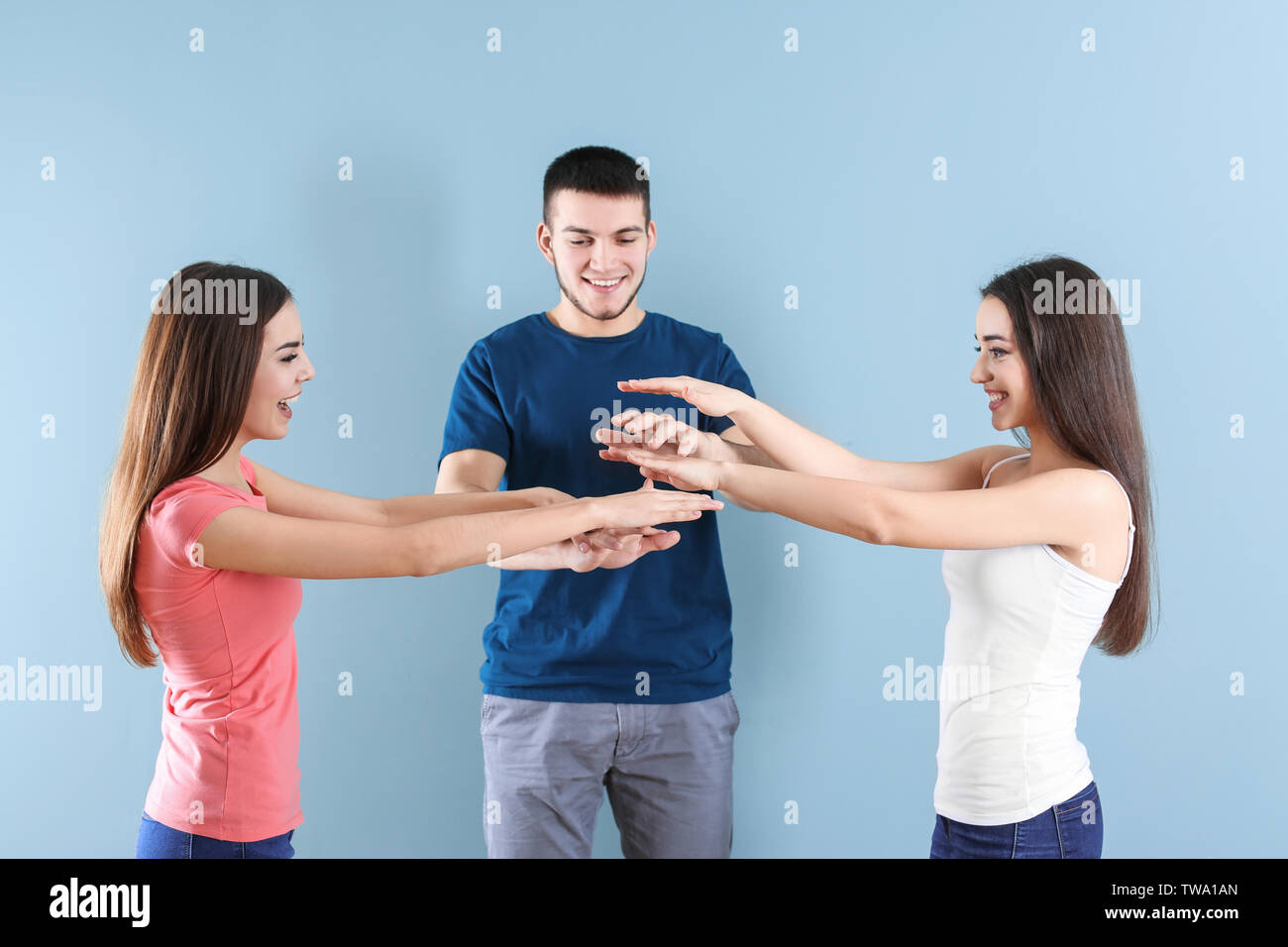 Young people putting hands together on color background. Unity concept ...