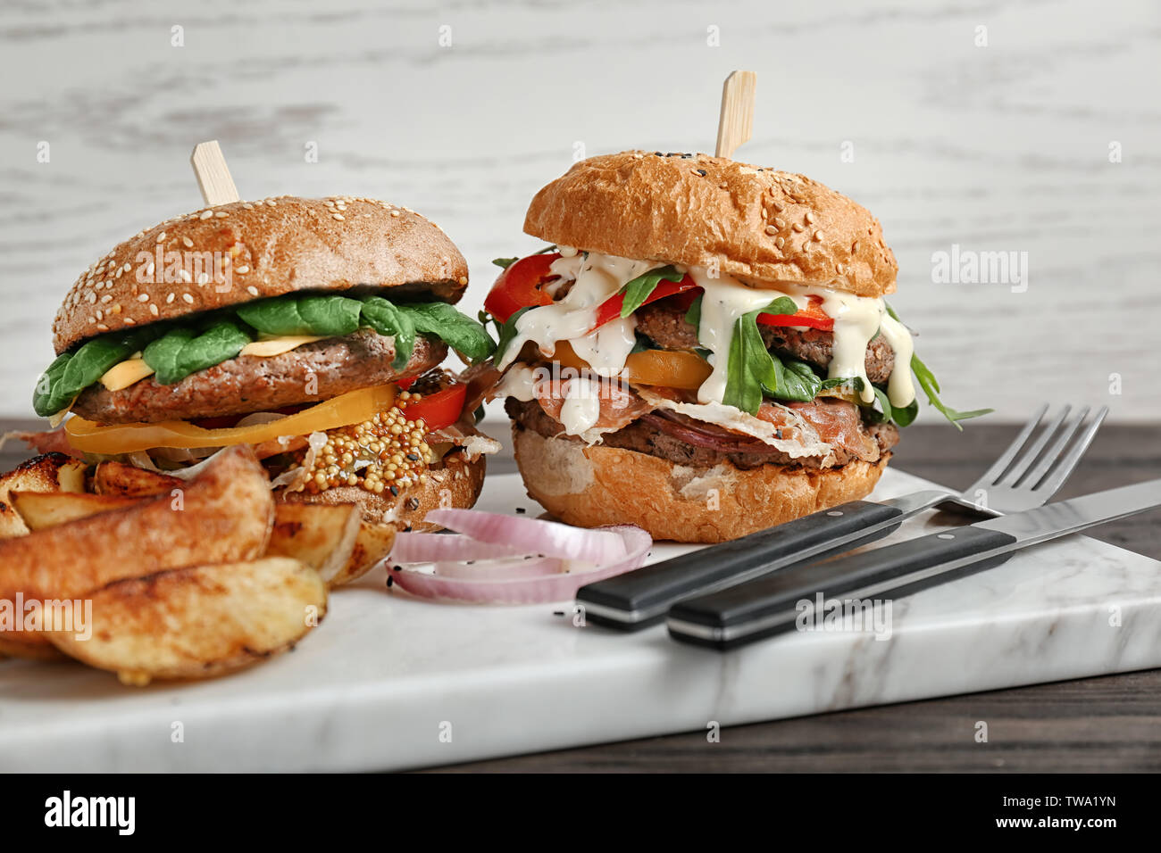 Tasty burgers and potatoes on marble board Stock Photo - Alamy