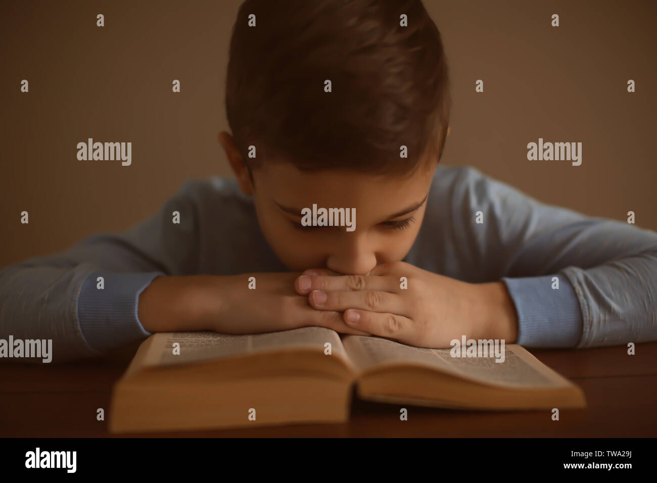 KYIV, UKRAINE - JANUARY 03, 2018: Little boy reading Bible at table ...