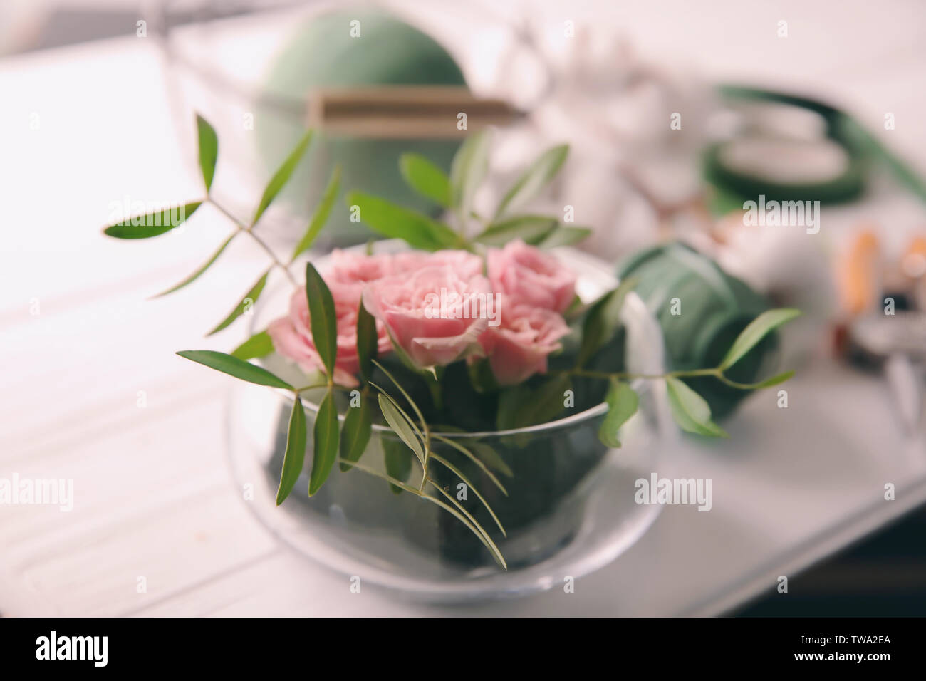 Glass bowl with flowers in sponge on table Stock Photo - Alamy