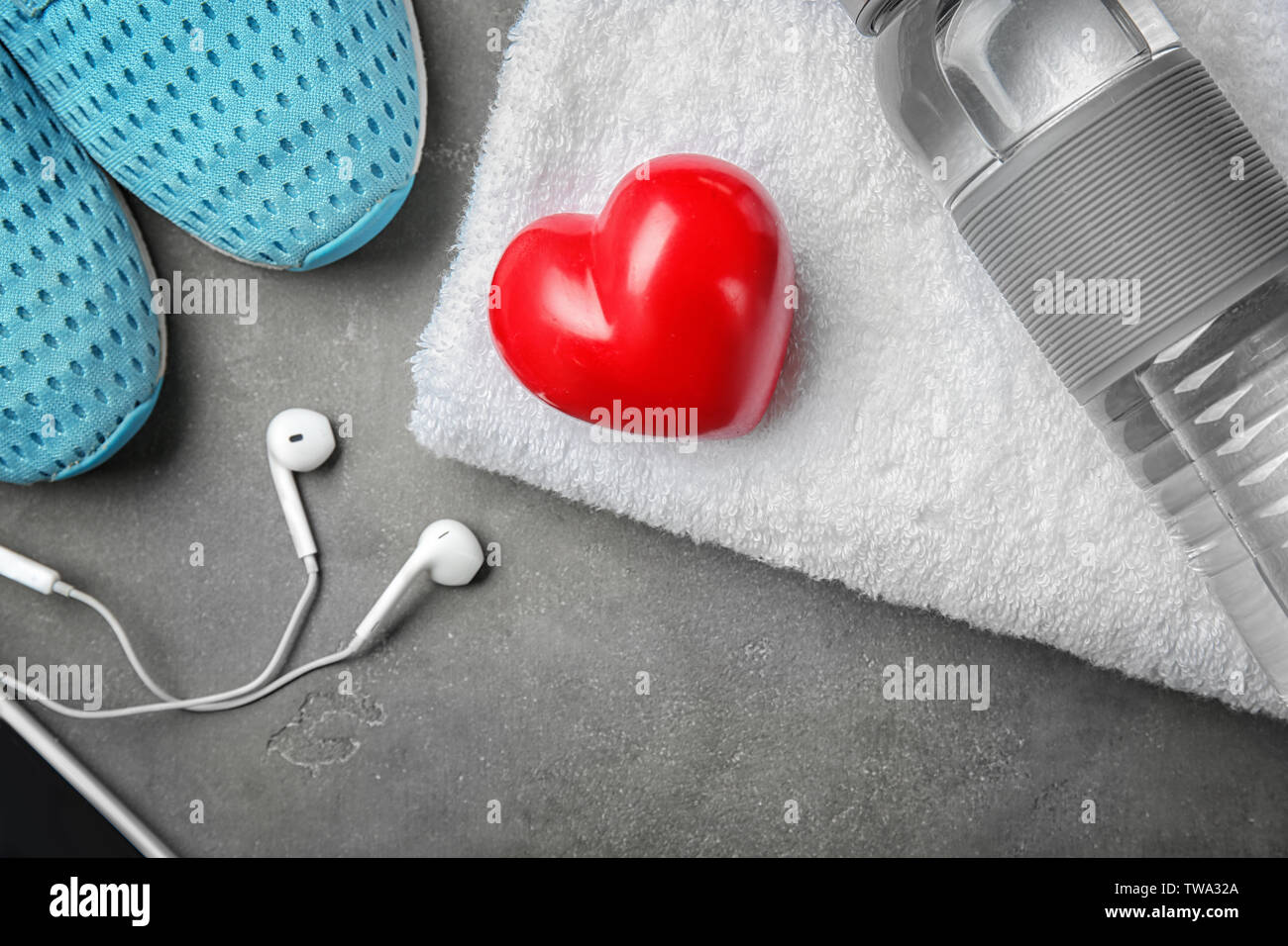 Gym stuff and red heart on grey background. Cardio training concept ...