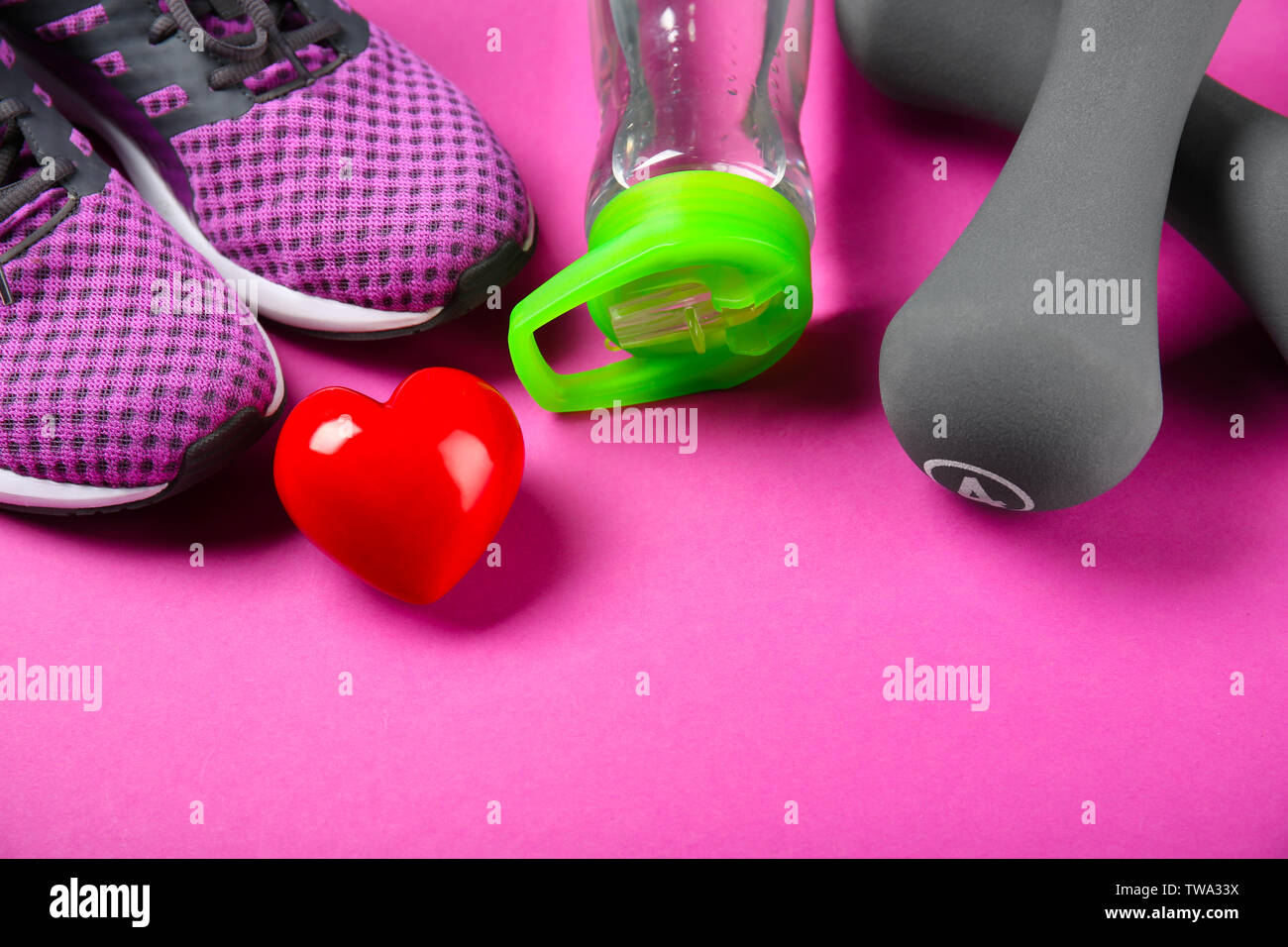 Gym stuff and red heart on color background. Cardio training concept ...