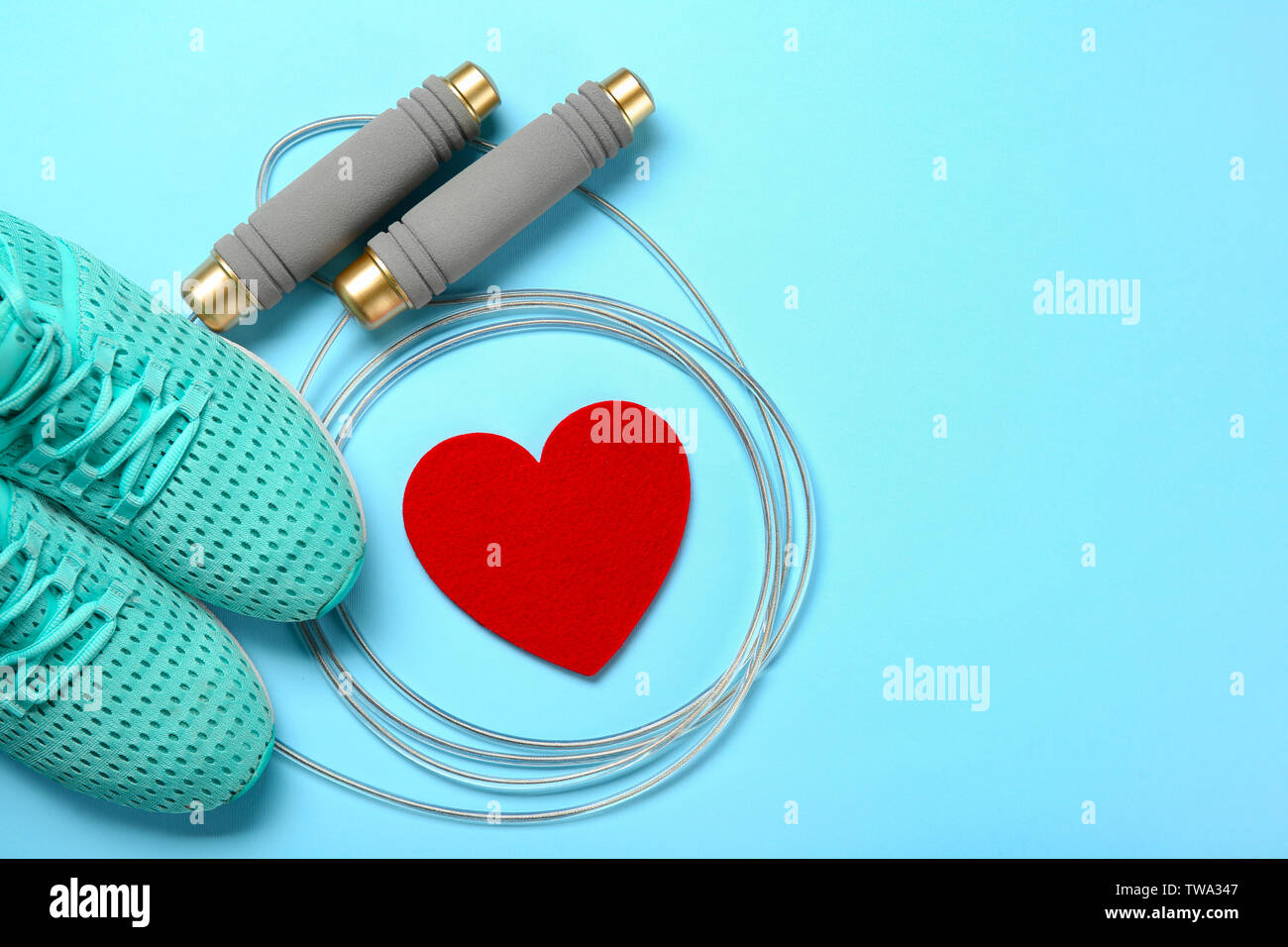 Gym stuff and red heart on color background. Cardio training concept ...