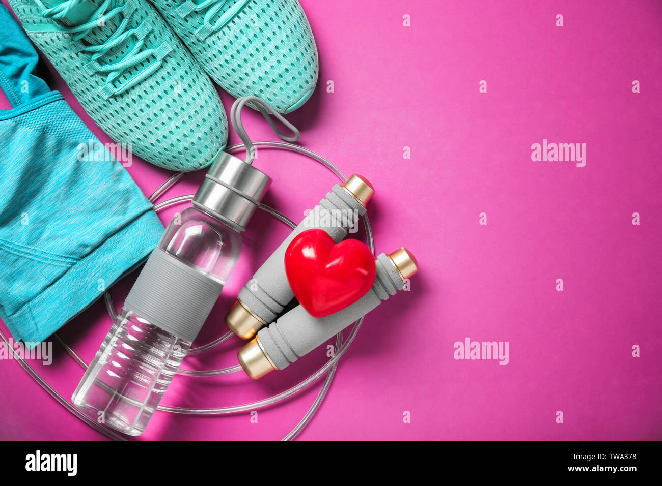 Gym stuff and red heart on color background. Cardio training concept ...