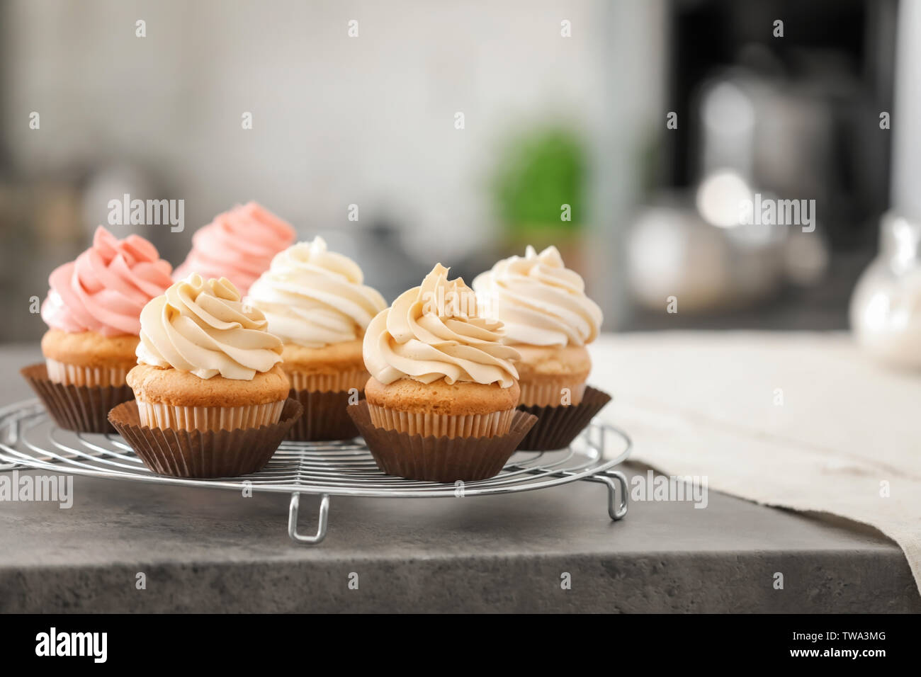 Cooling rack with tasty cupcakes on table Stock Photo - Alamy