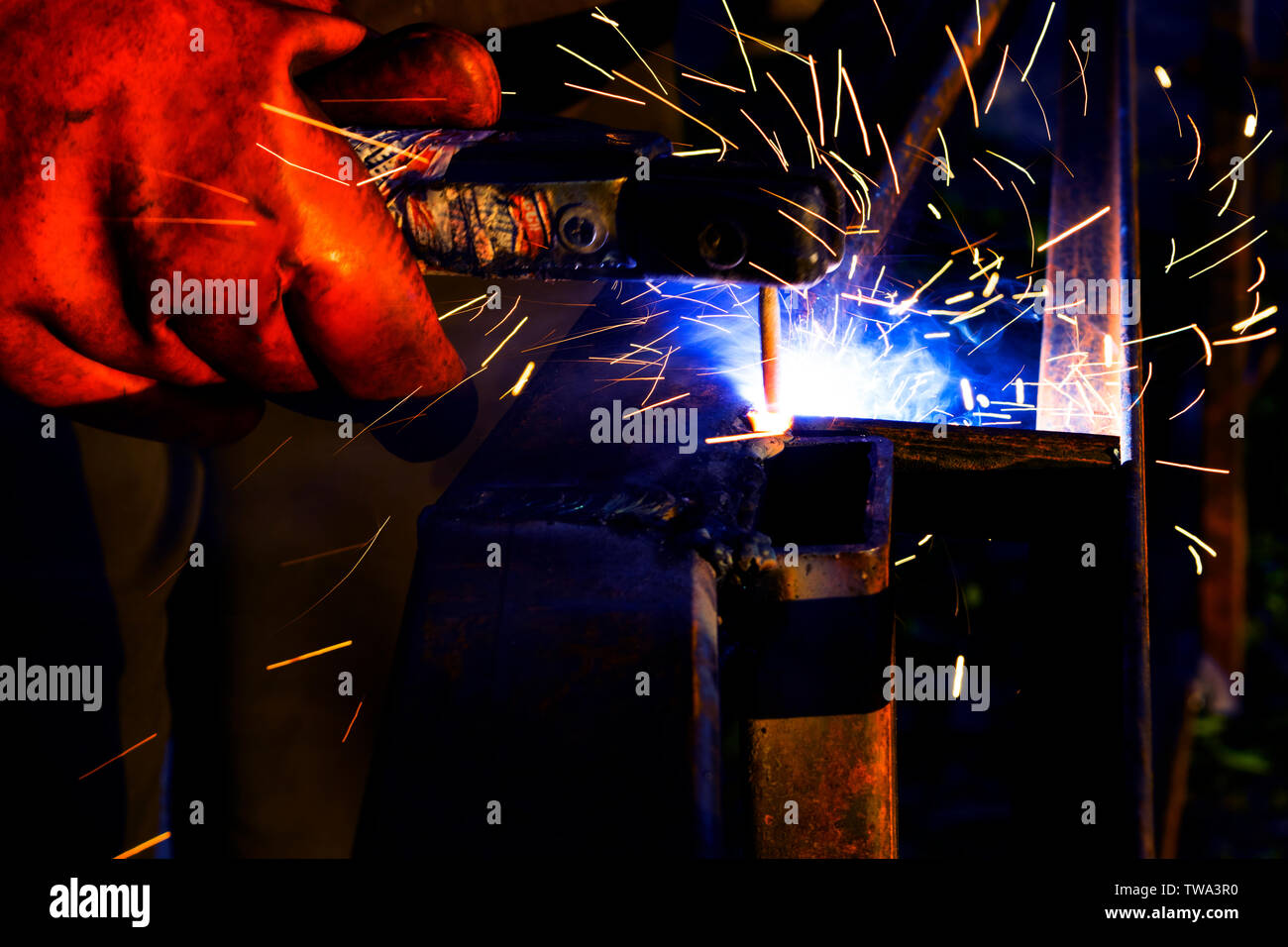 Welder worker performs jump welding. Man welder in protective gloves ...