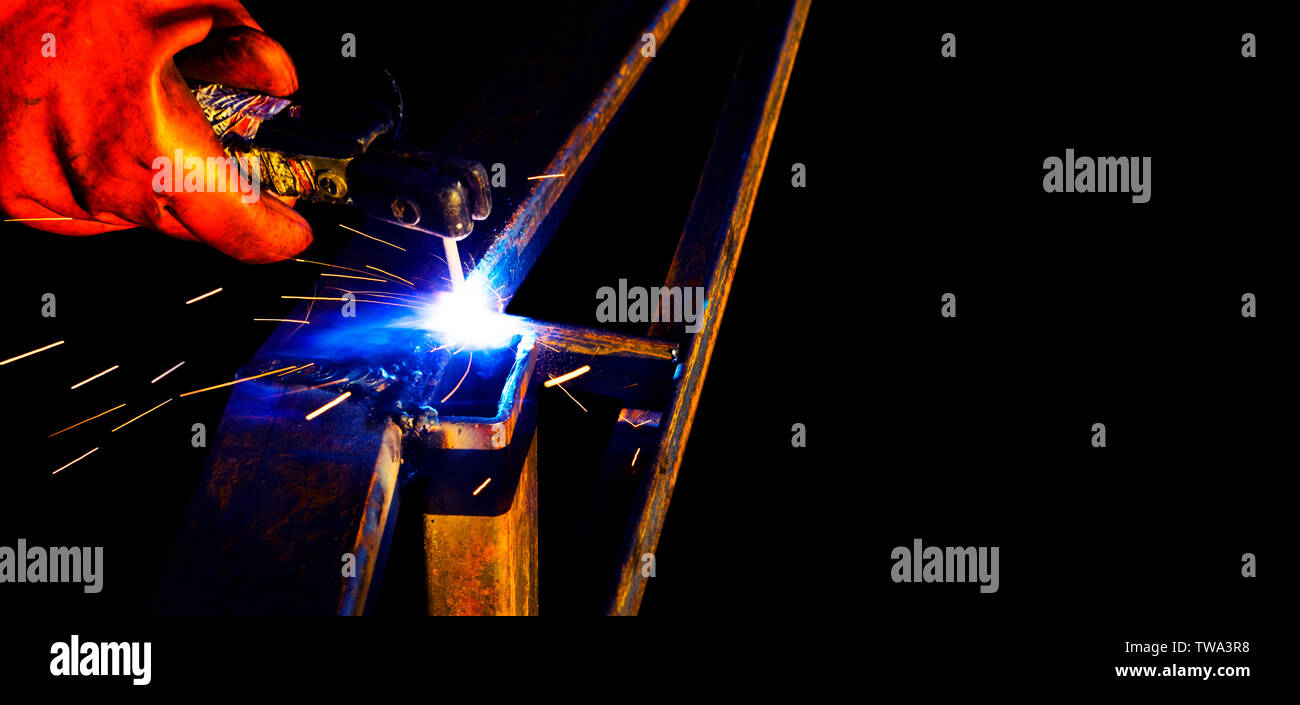 Welder worker performs jump welding. Man welder in protective gloves ...