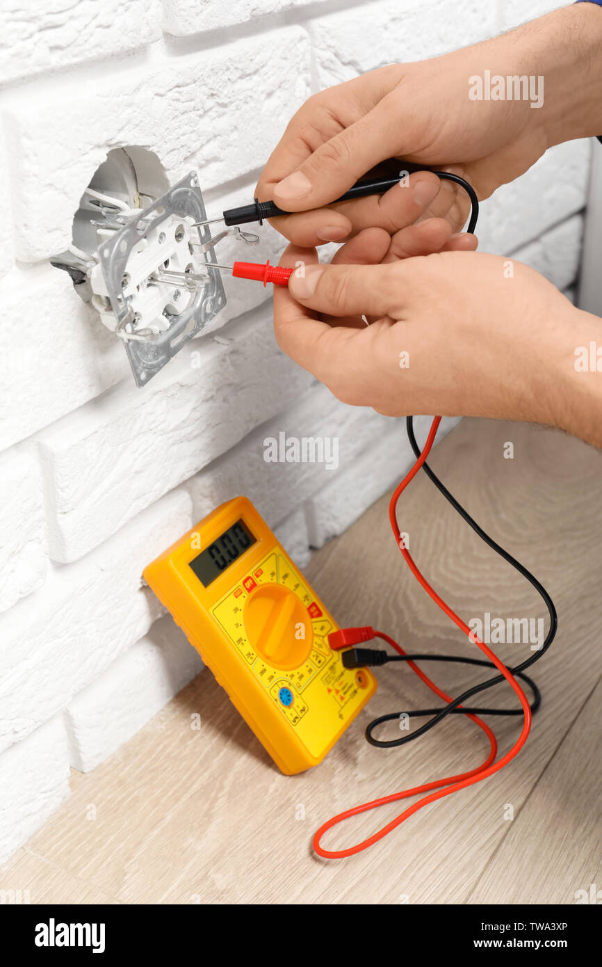 Electrician measuring voltage of socket Stock Photo - Alamy