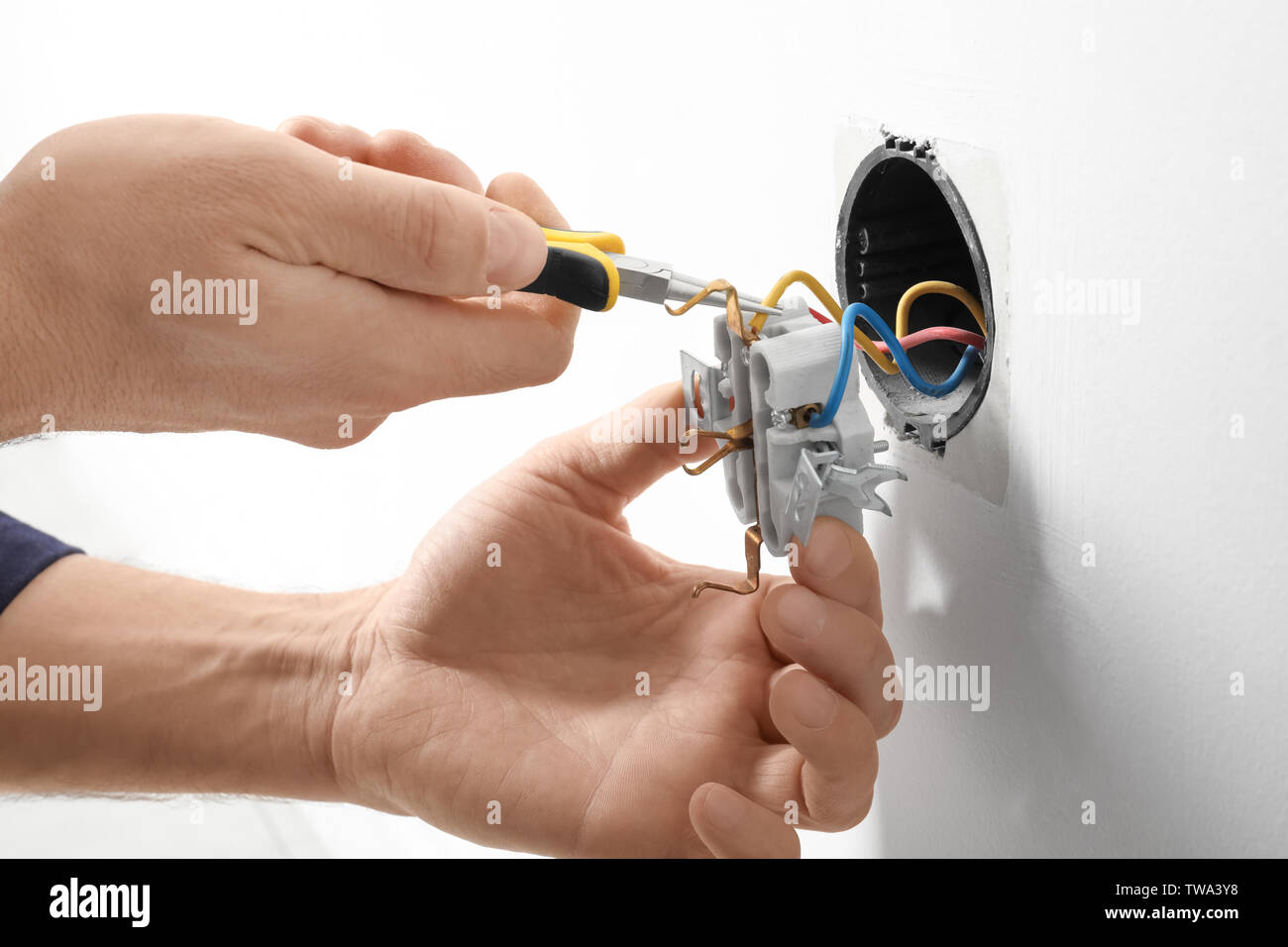 Electrician repairing socket on light wall Stock Photo - Alamy