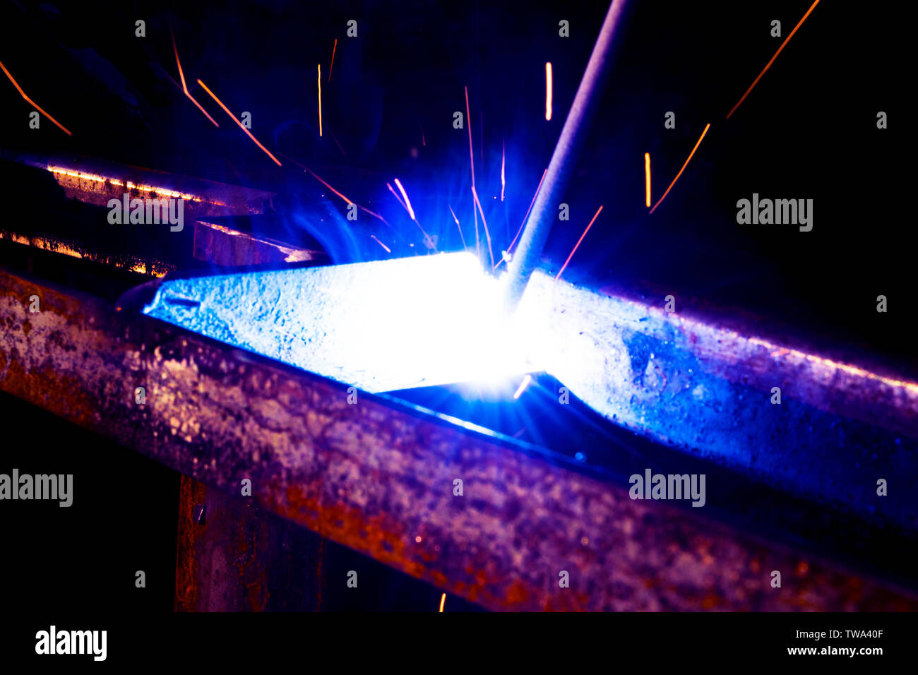 Welder worker performs jump welding. Man welder in protective gloves ...