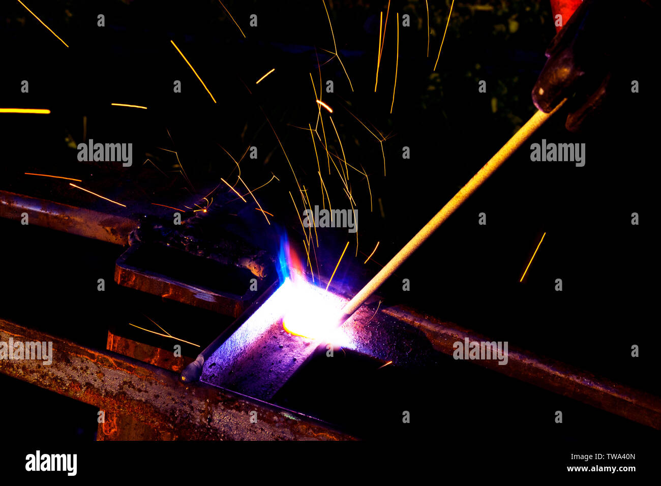 Welder worker performs jump welding. Man welder in protective gloves ...