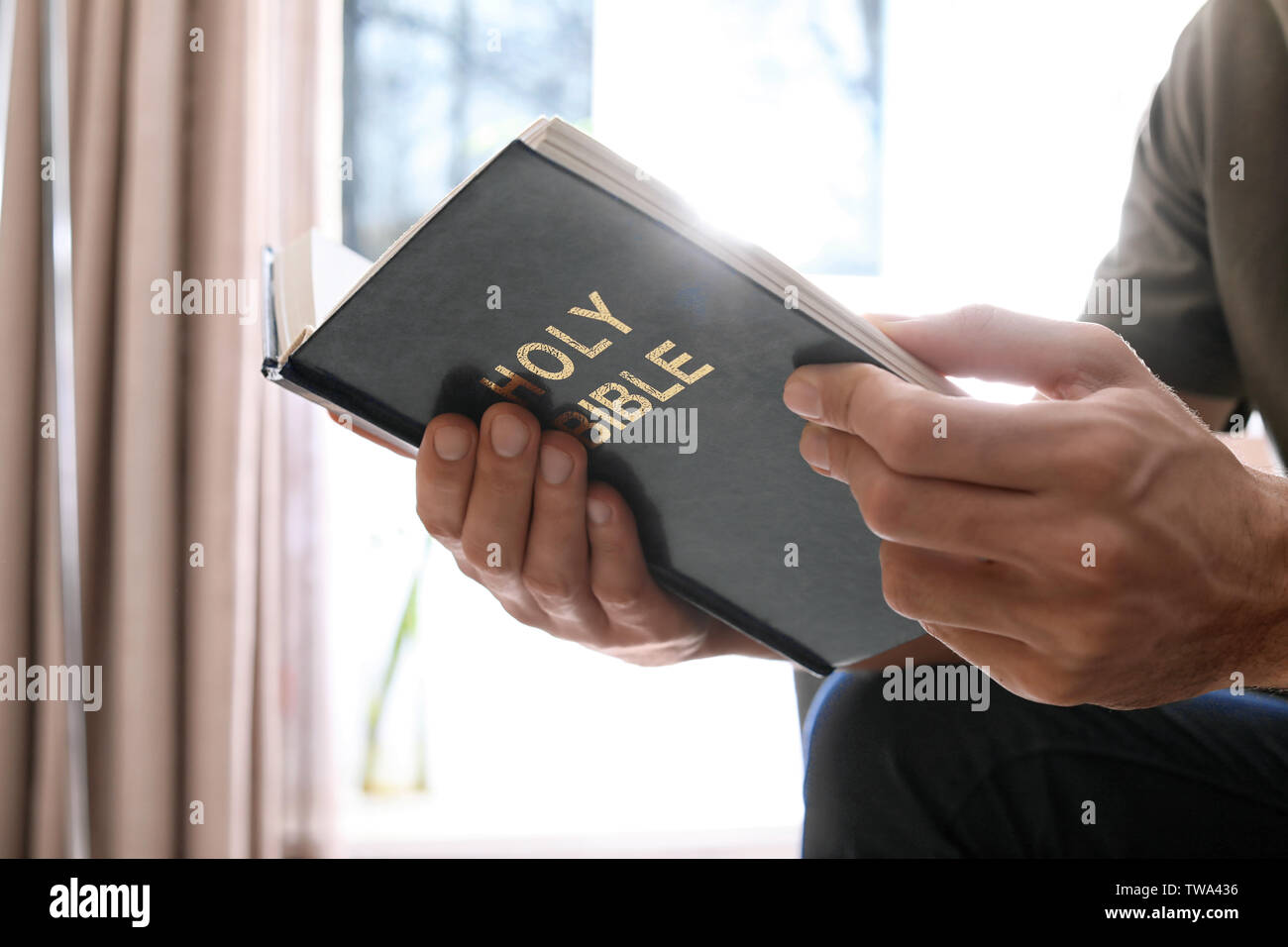 Religious young man reading Bible at home Stock Photo - Alamy