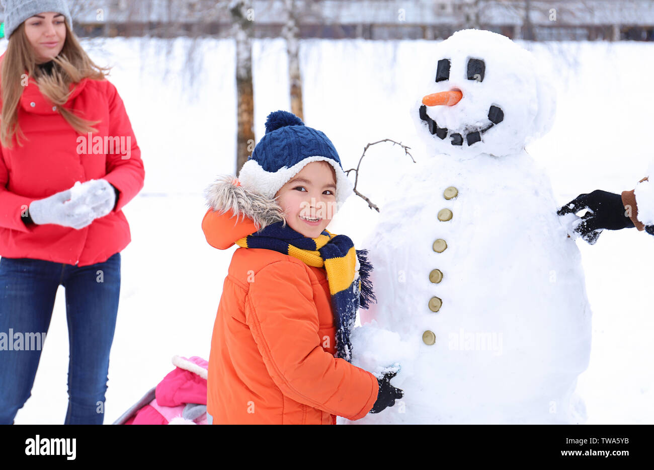 Happy family making snowman in park on winter vacation Stock Photo - Alamy