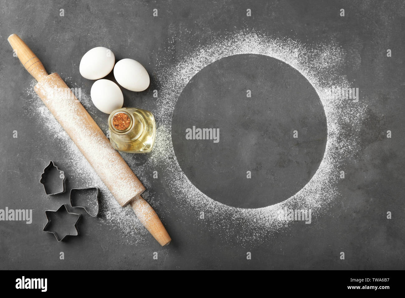 Composition with round frame made of flour on grey background, top view ...