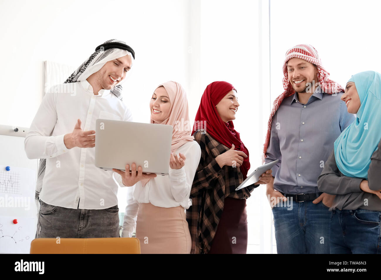 Muslim office employees in traditional clothes having business meeting ...