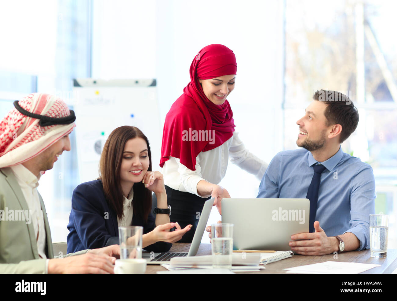 Office employees and their Muslim coworkers having business meeting in ...