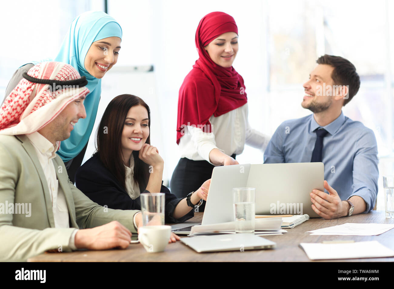 Office employees and their Muslim coworkers having business meeting in ...
