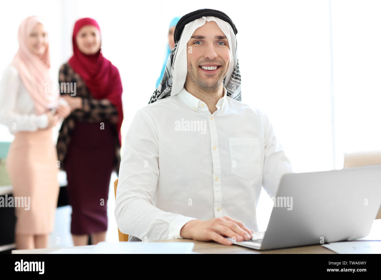 Muslim businessman in traditional clothes at workplace Stock Photo - Alamy