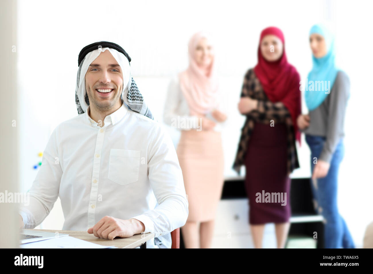 Muslim businessman in traditional clothes at workplace Stock Photo - Alamy