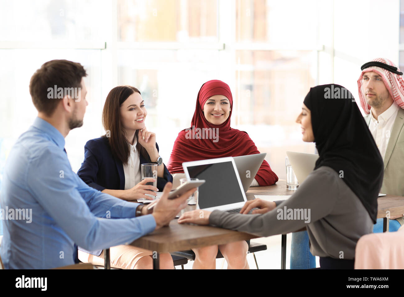 Office employees and their Muslim coworkers having business meeting in ...