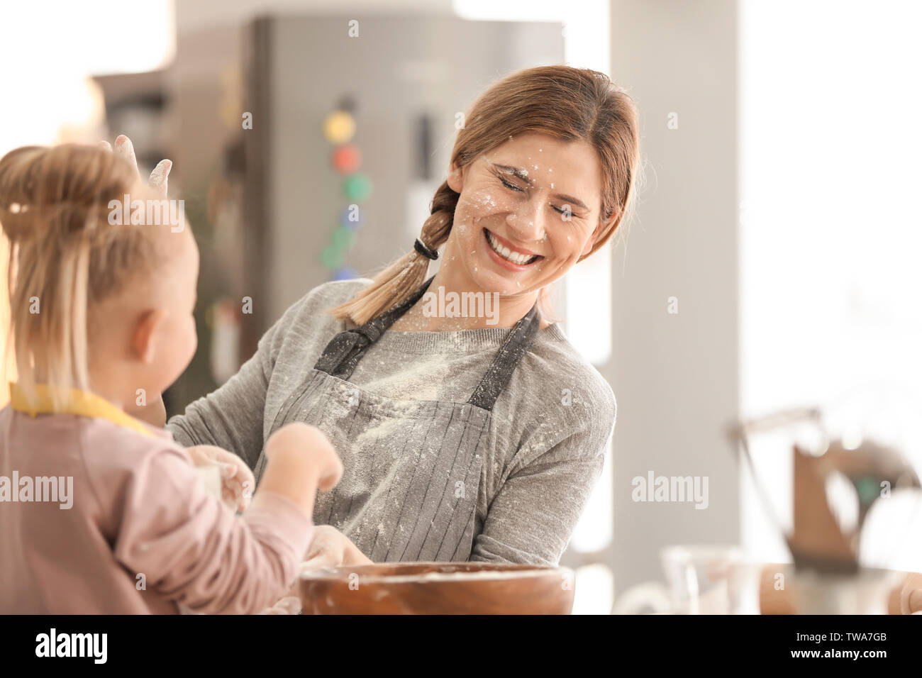 Mother and daughter having fun with flour in kitchen Stock Photo - Alamy