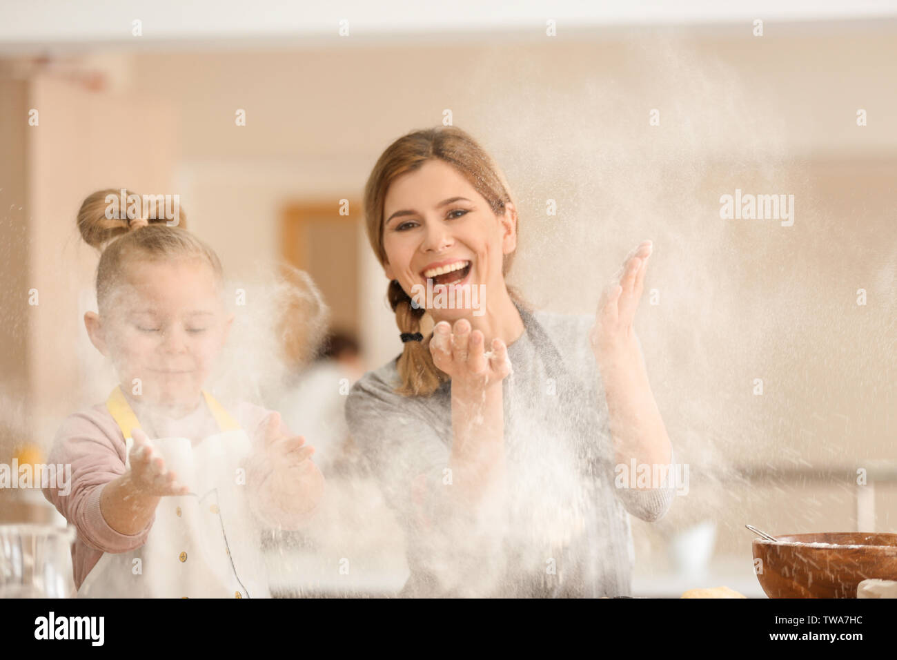 Mother and daughter having fun with flour in kitchen Stock Photo - Alamy