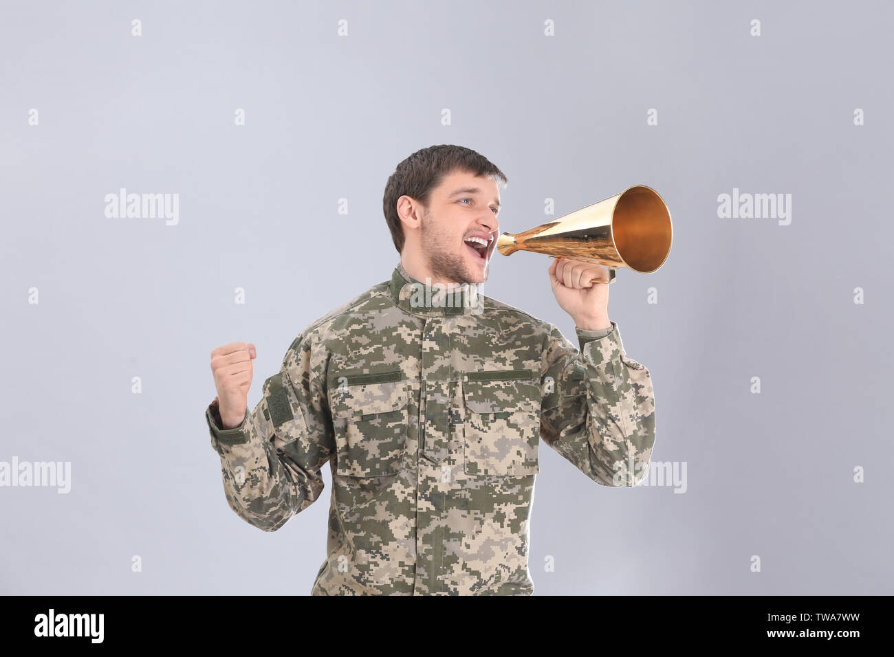 Military man shouting into megaphone on grey background Stock Photo - Alamy
