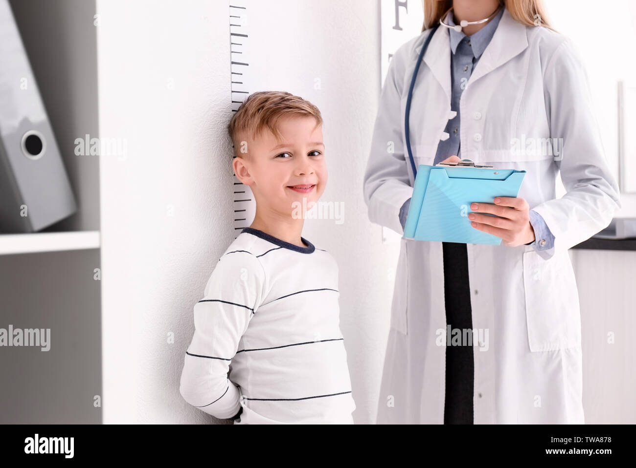 Young female doctor measuring height of little boy in hospital Stock ...