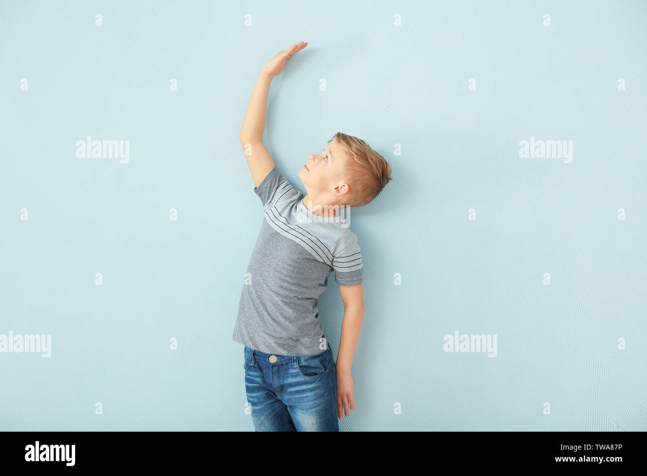Cute little boy measuring height near color wall Stock Photo - Alamy