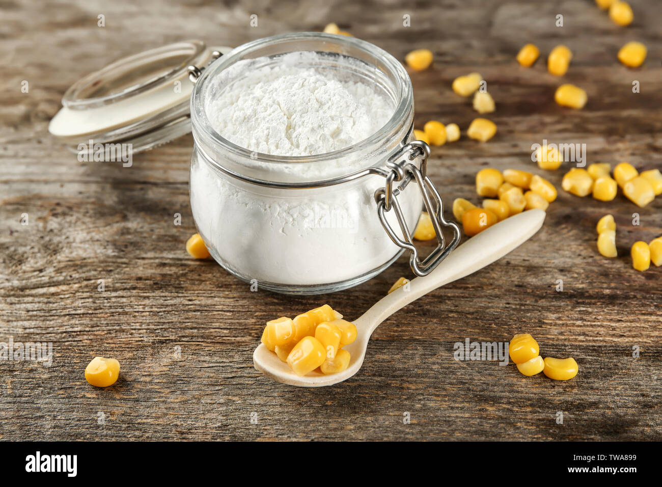 Spoon with kernels and corn starch in jar on wooden table Stock Photo ...