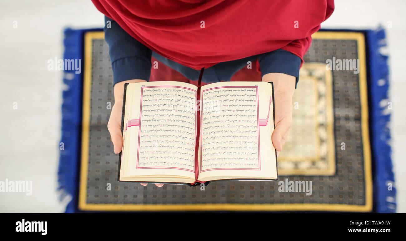 Young Muslim woman reading Koran, indoors Stock Photo - Alamy
