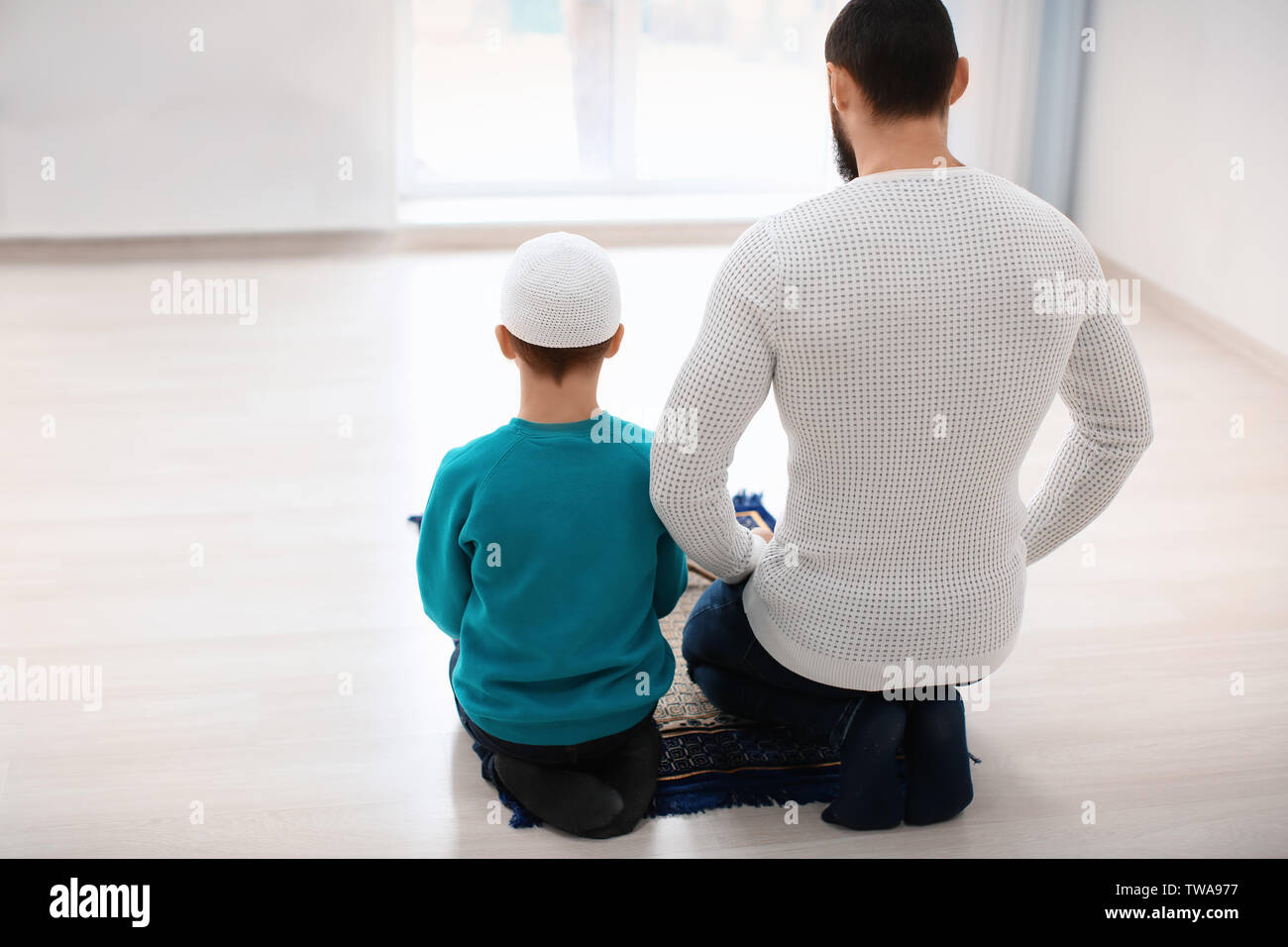 Muslim father and son praying together, indoors Stock Photo - Alamy
