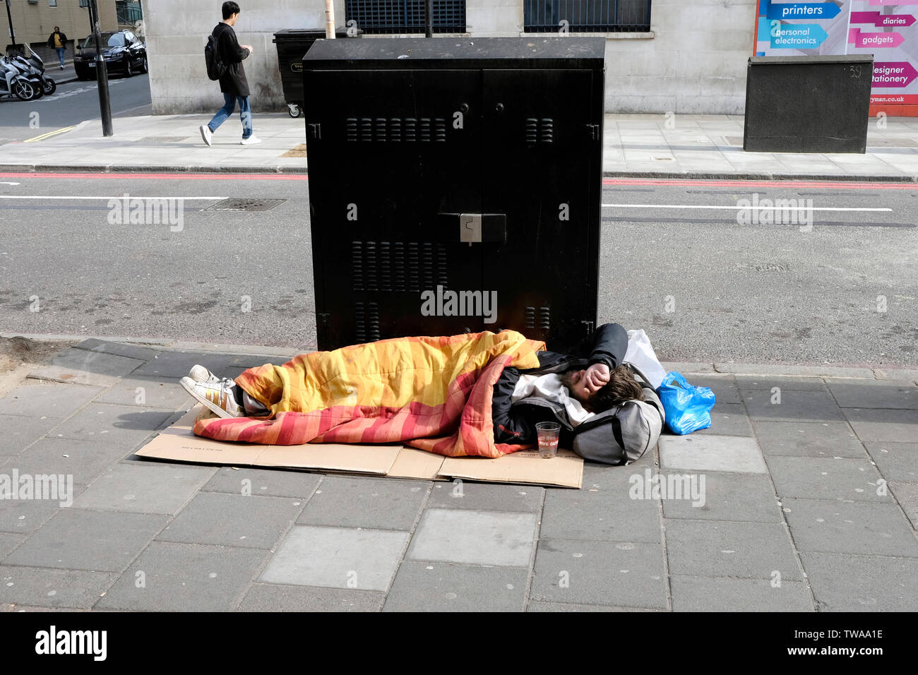 A homeless man sleeping on a pavement, Edgware Road, central London ...