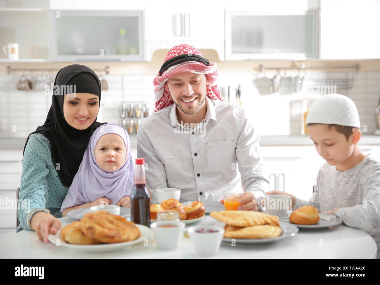 Happy Muslim family having breakfast together at home Stock Photo - Alamy