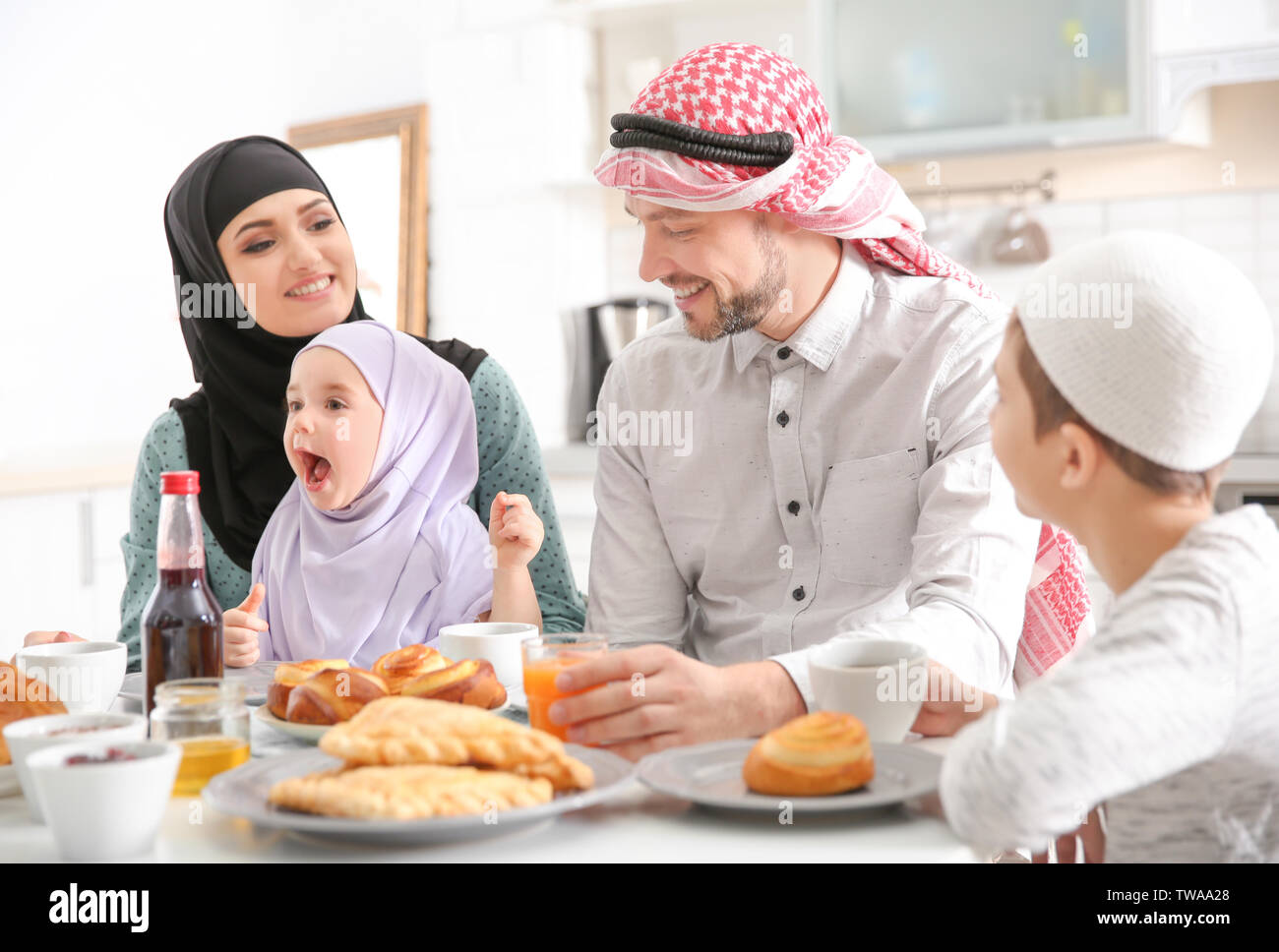 Happy Muslim family having breakfast together at home Stock Photo - Alamy
