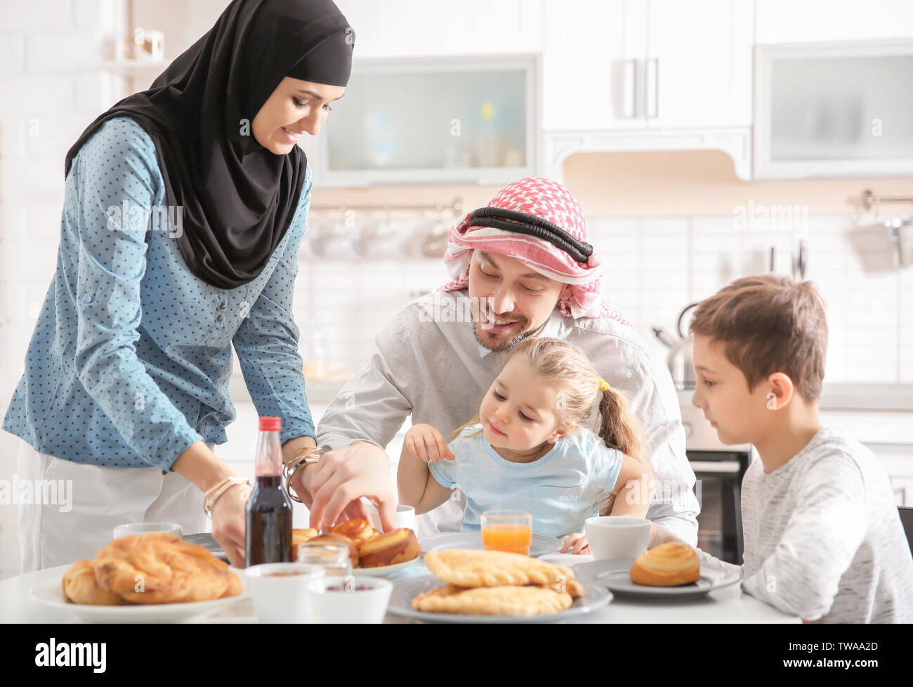 Happy Muslim family having breakfast together at home Stock Photo - Alamy