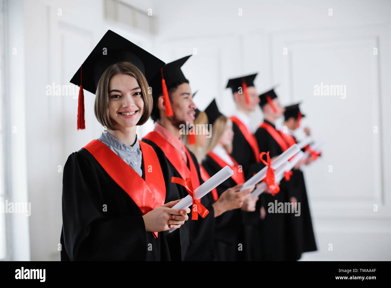 Students in bachelor robes with diplomas indoors. Graduation day Stock ...