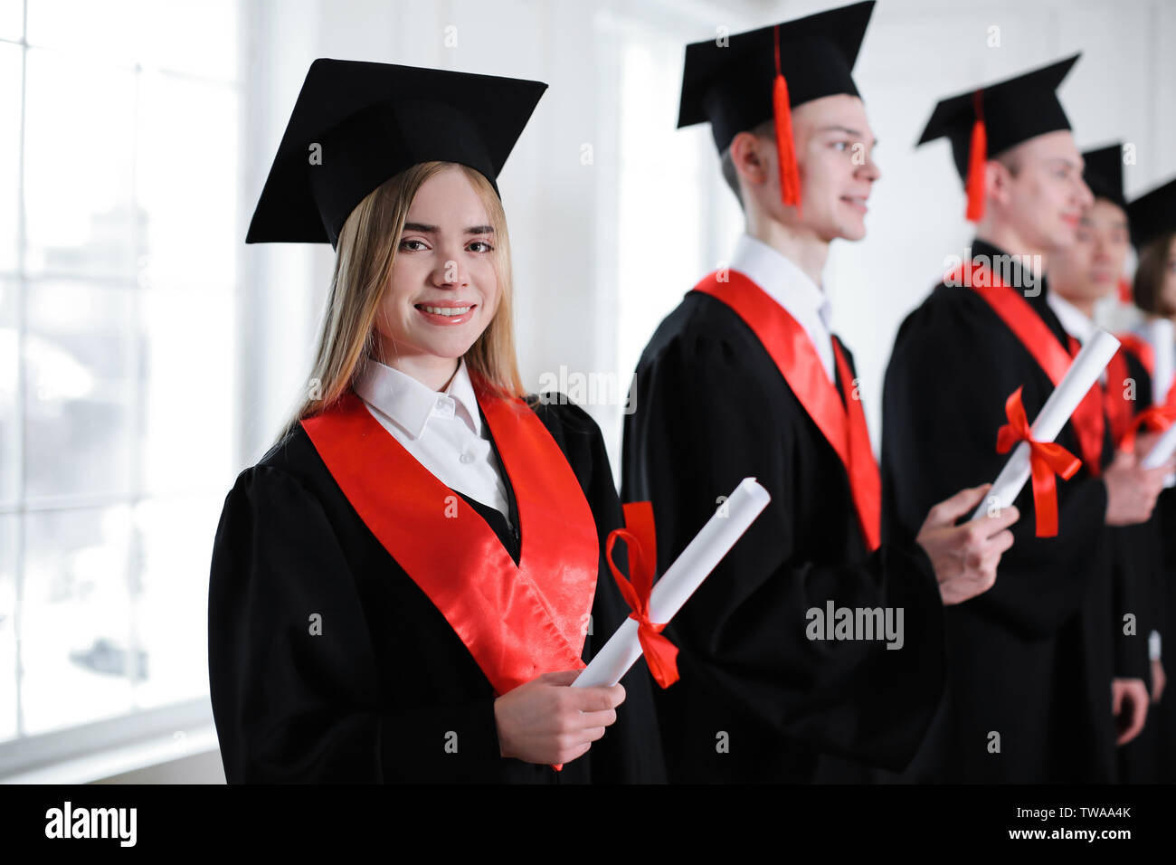 Students in bachelor robes with diplomas indoors. Graduation day Stock ...