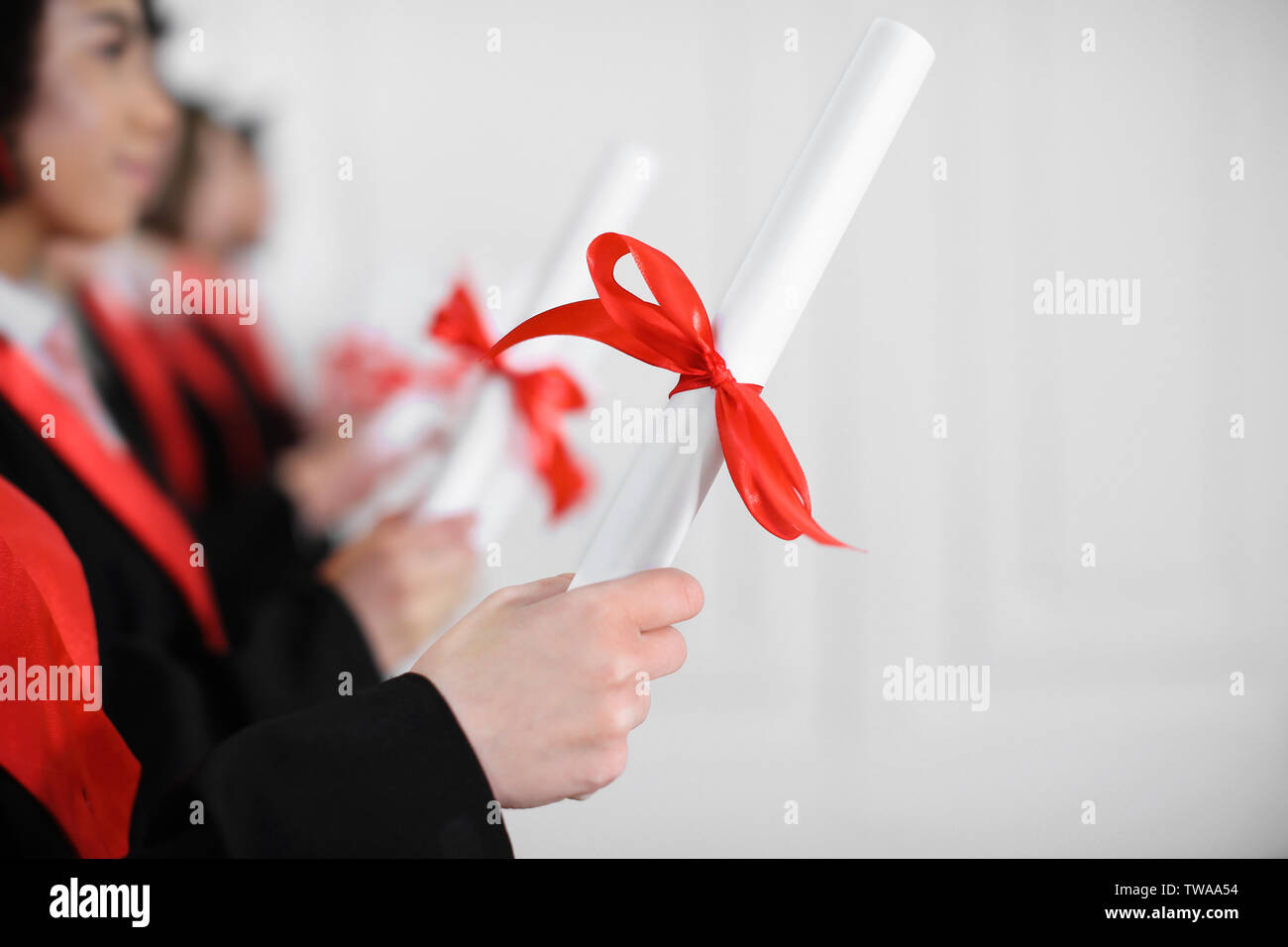 Students in bachelor robes with diplomas indoors. Graduation day Stock ...