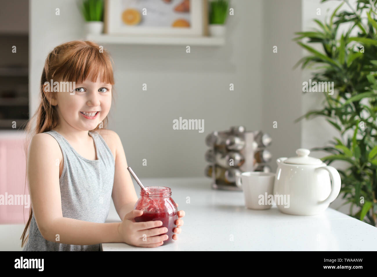 Cute little girl with jar of jam at home Stock Photo - Alamy