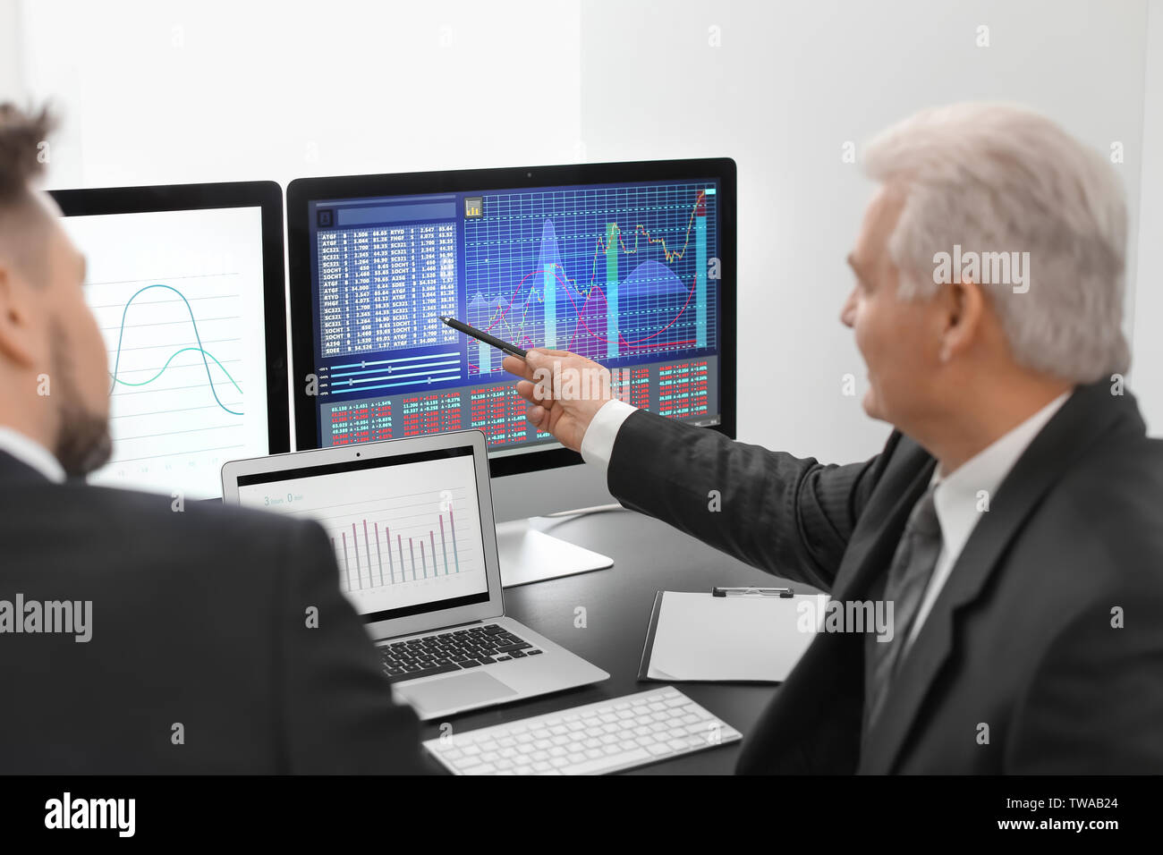 Male brokers working in office. Finance trading concept Stock Photo - Alamy