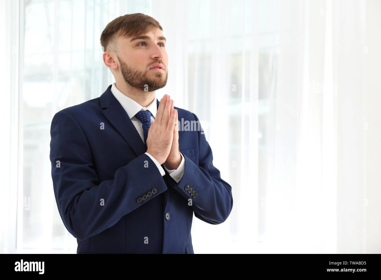 Religious young man praying indoors Stock Photo - Alamy